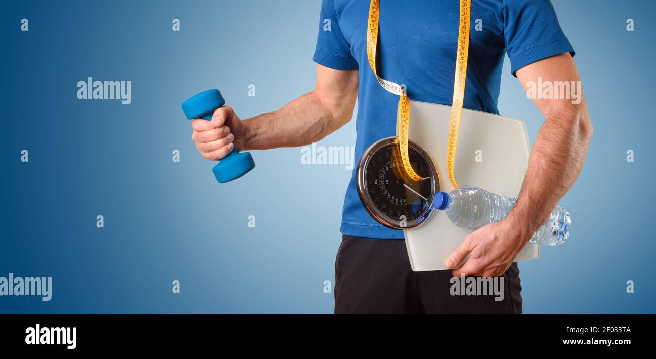 Athletic man with scale and measuring tape hanging from the neck water ...