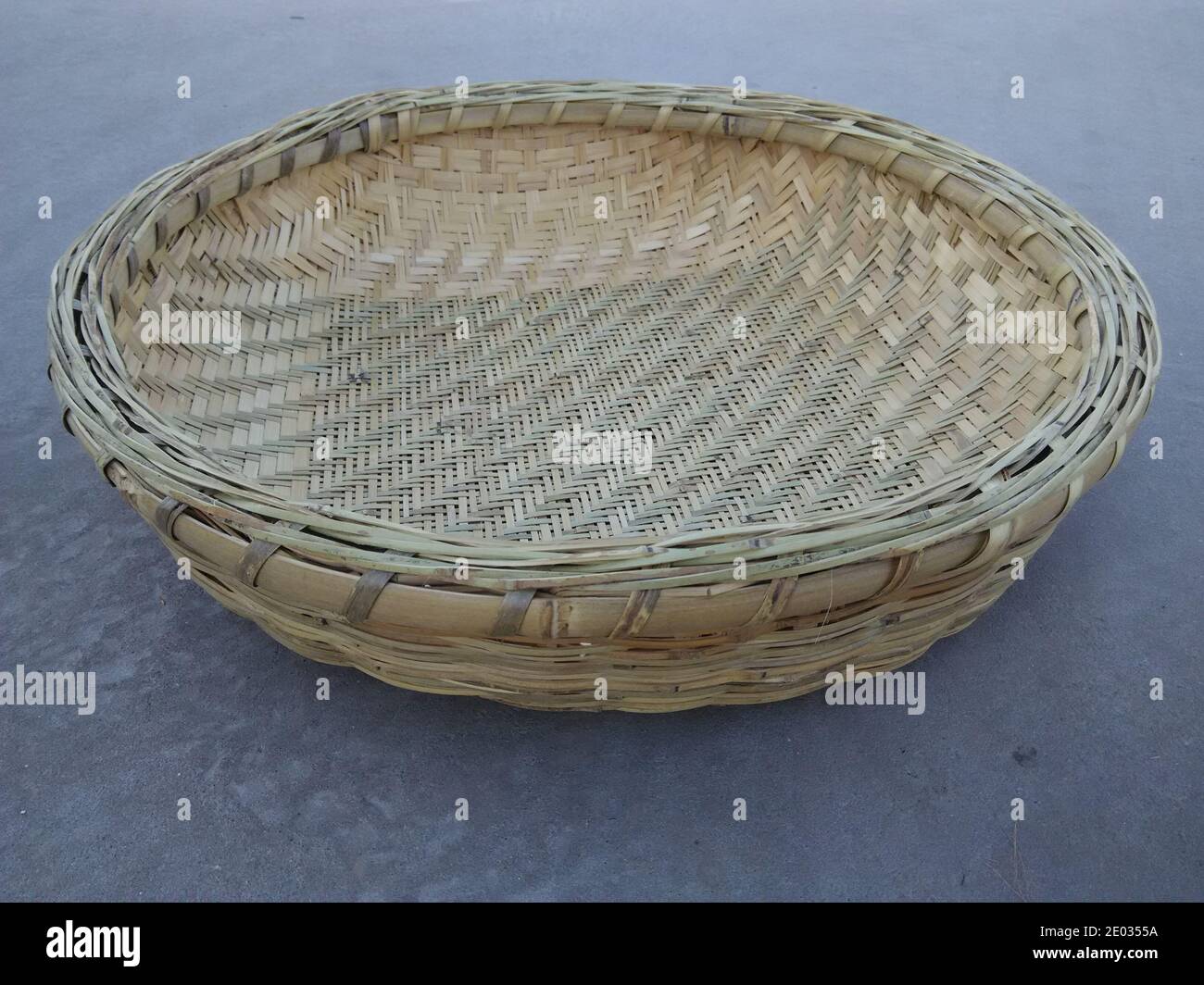Empty wicker basket, handwoven round threshing basket on the ground ...