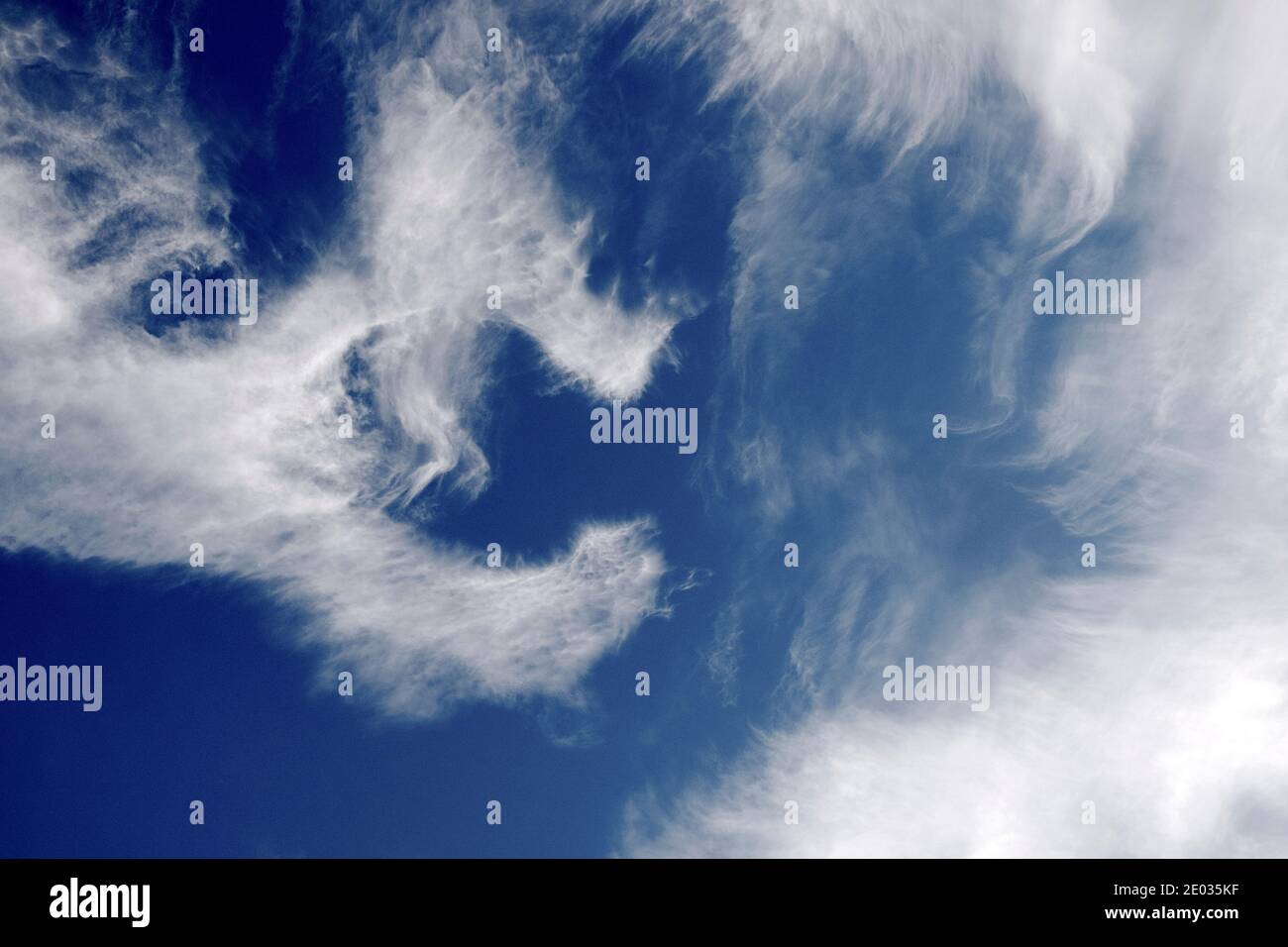 Cirrus clouds forming the letter C shape in blue sky in winter on ...