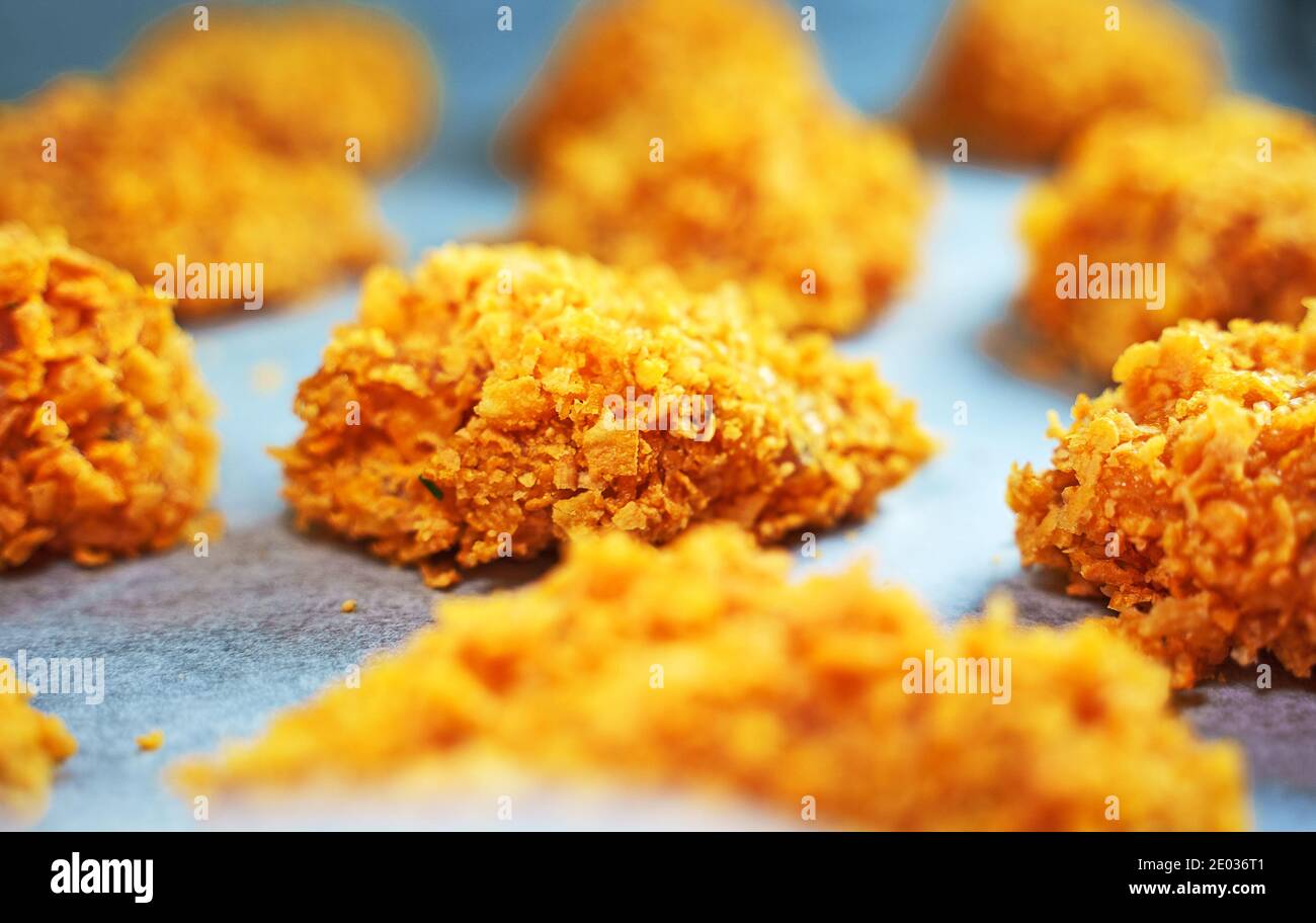 Chicken nuggets on parchment paper before baking Stock Photo - Alamy