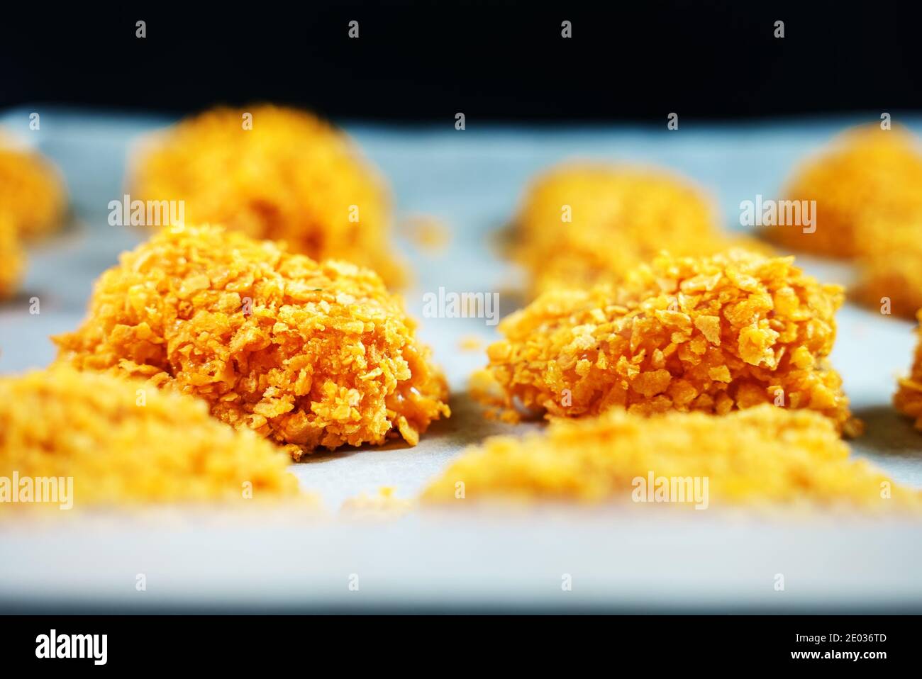 Chicken nuggets on parchment paper before baking Stock Photo - Alamy