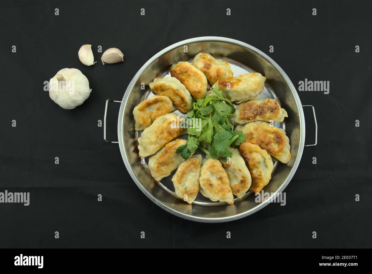 Top view of fried pot stickers, dumplings, and celery in a pan, black ...