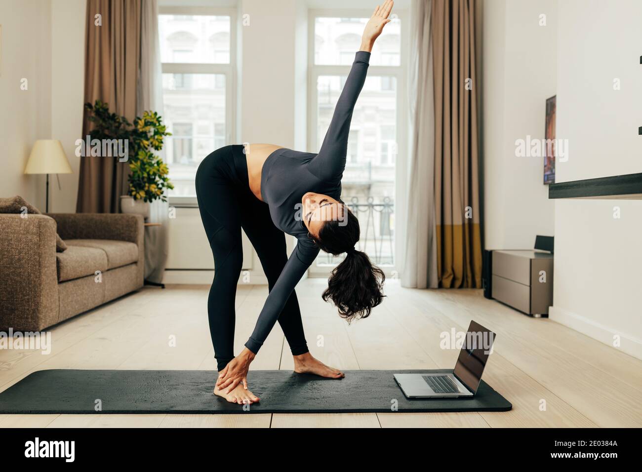 Woman repeating exercises at home. Young female keeps fit while staying ...
