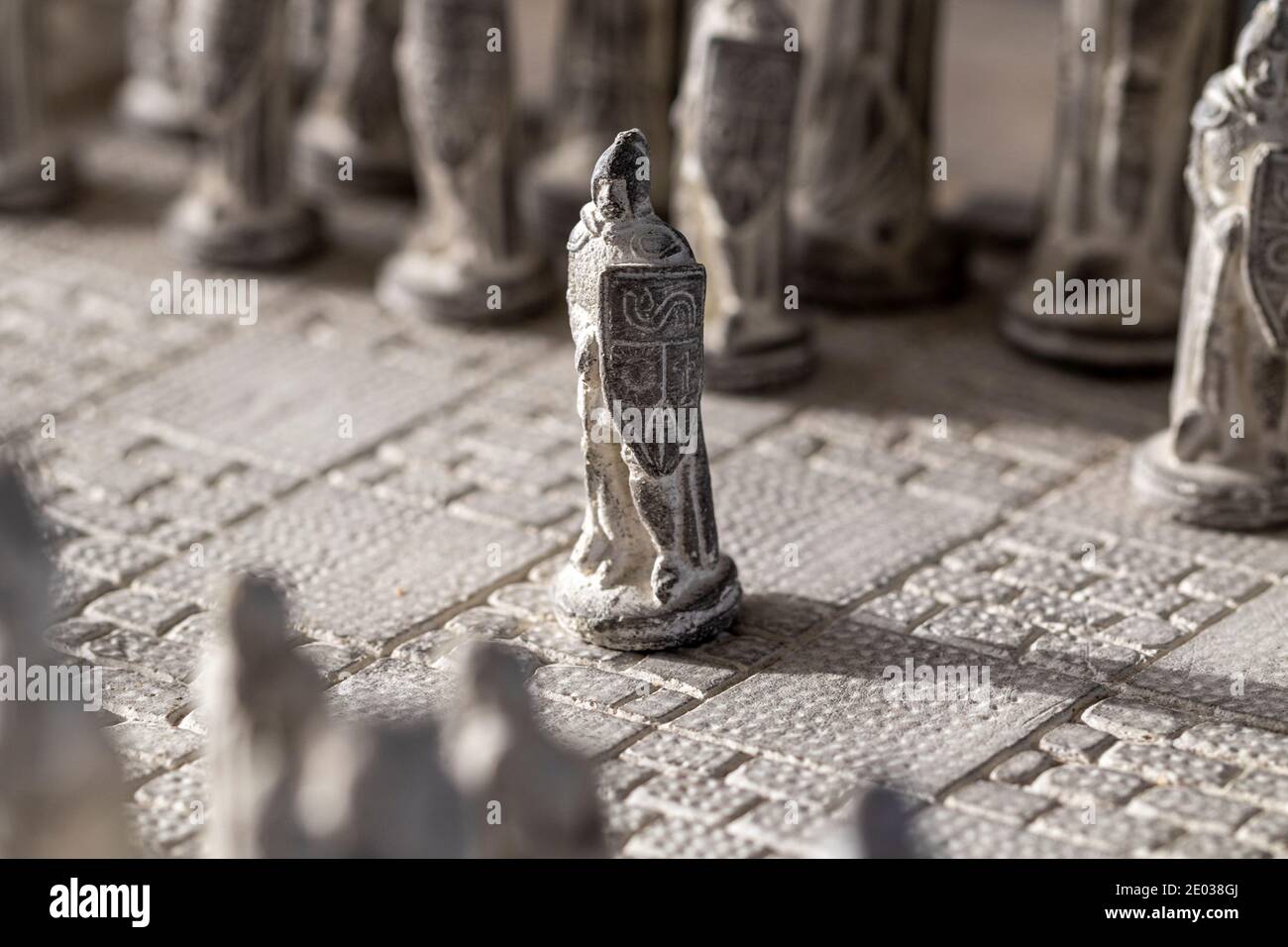 A portrait of a stone soldier as a pawn on a chessboard. The chess game ...