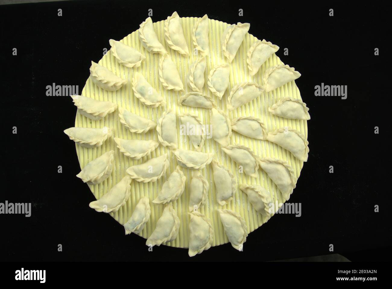 Top view of raw handmade dumplings on food cloth, black background ...