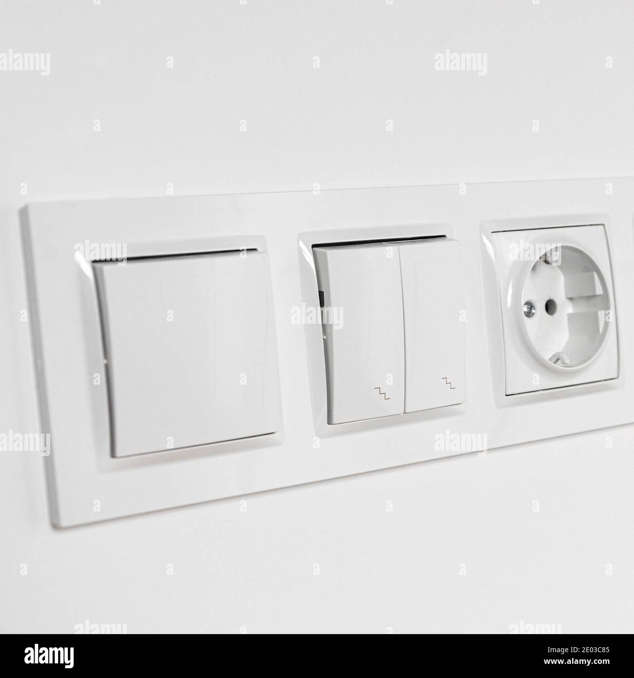 White plastic walk-through switches and sockets on a white wall Stock ...