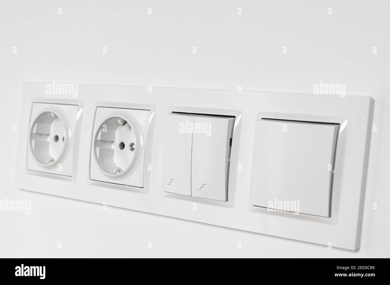 White plastic walk-through switches and sockets on a white wall Stock ...