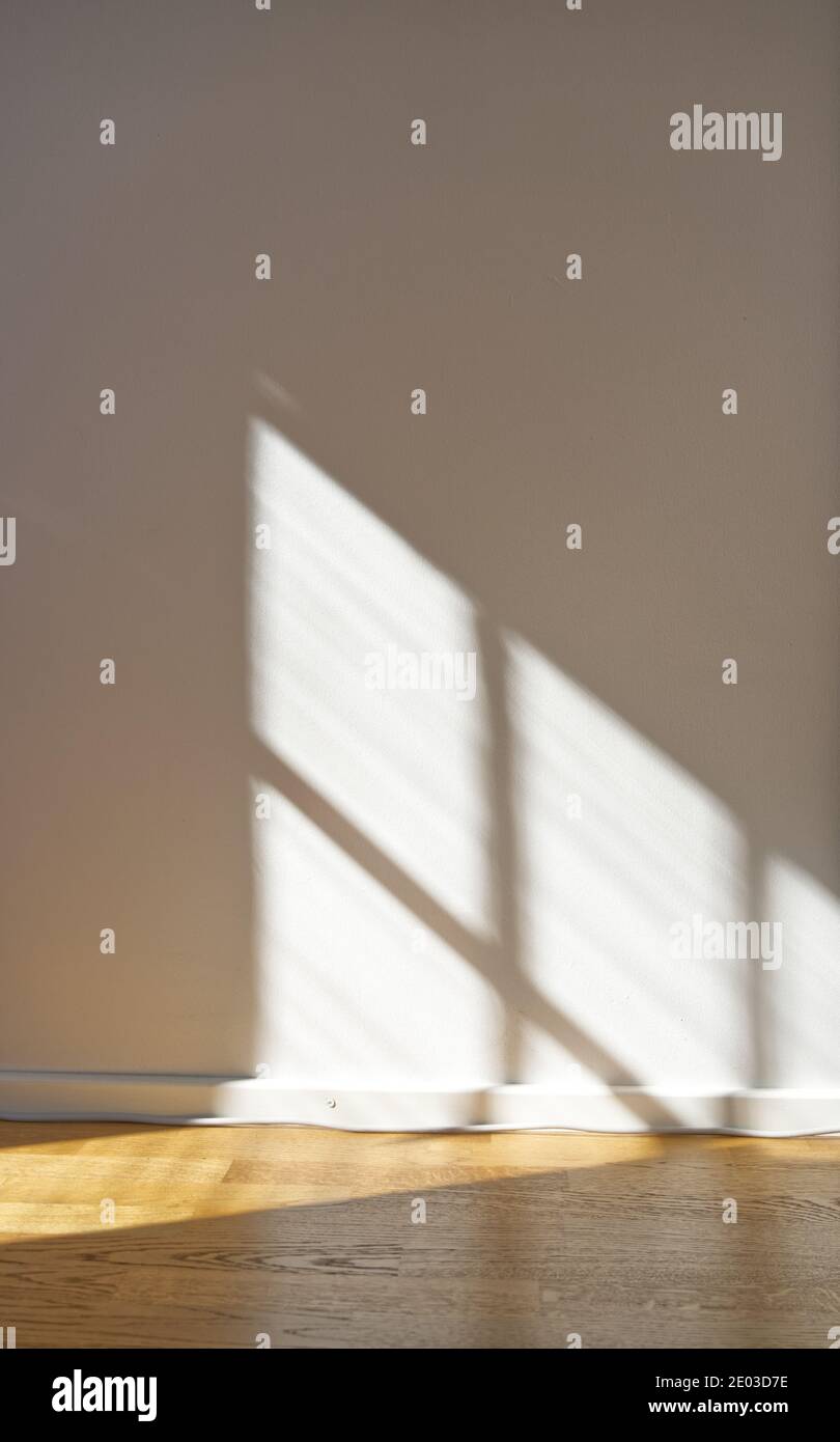 Sunlight on wall through the window. Empty interior with white wall and ...