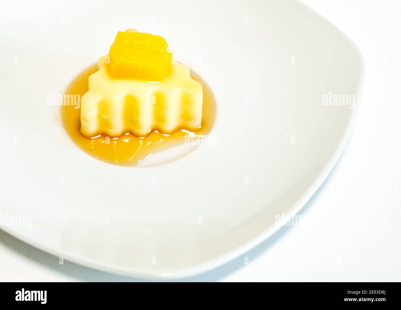 Homemade mango pudding with milk, mango mousse, dessert on white plate ...