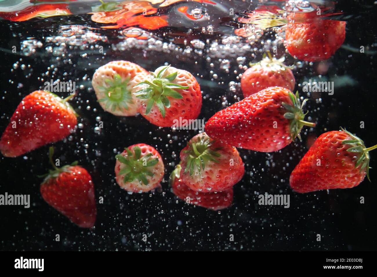Strawberries in water splash on black background, freeze motion Stock ...