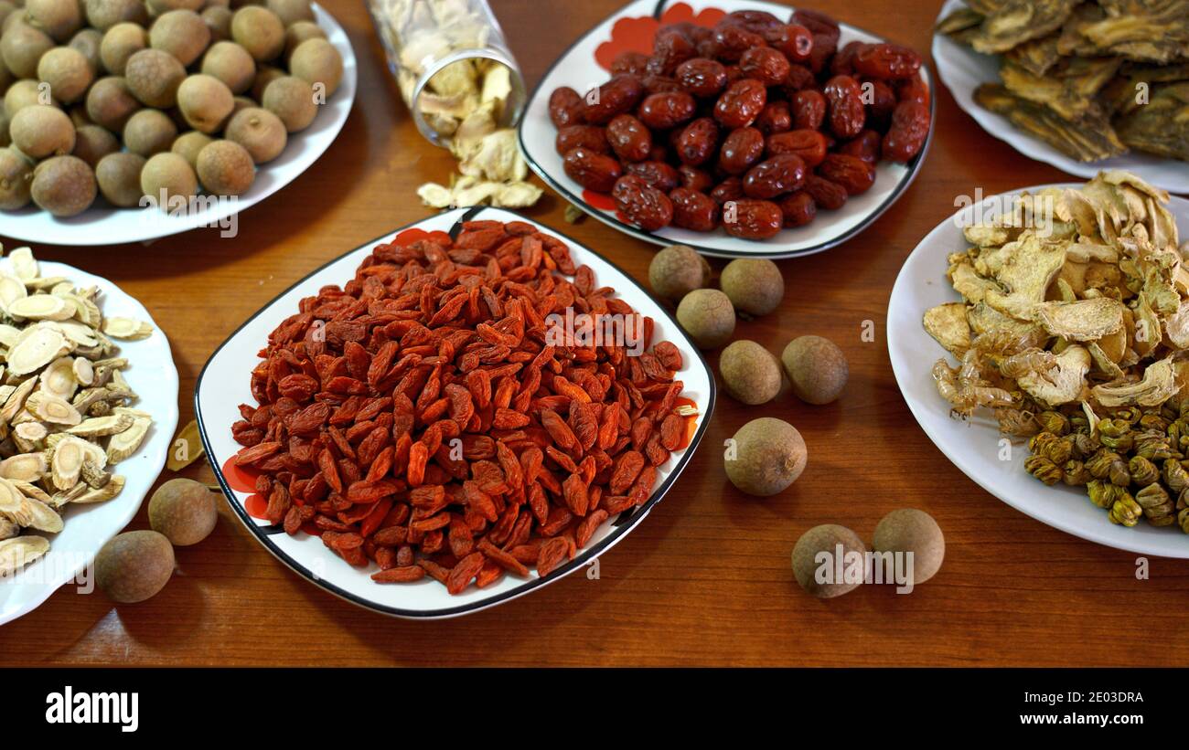 Goji berries, dried longans, red dates on wooden table, top view ...