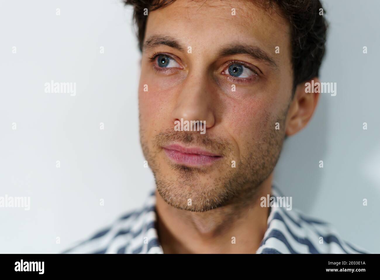 Selective focus of a young man's blue eyes with shirt and thoughtful ...
