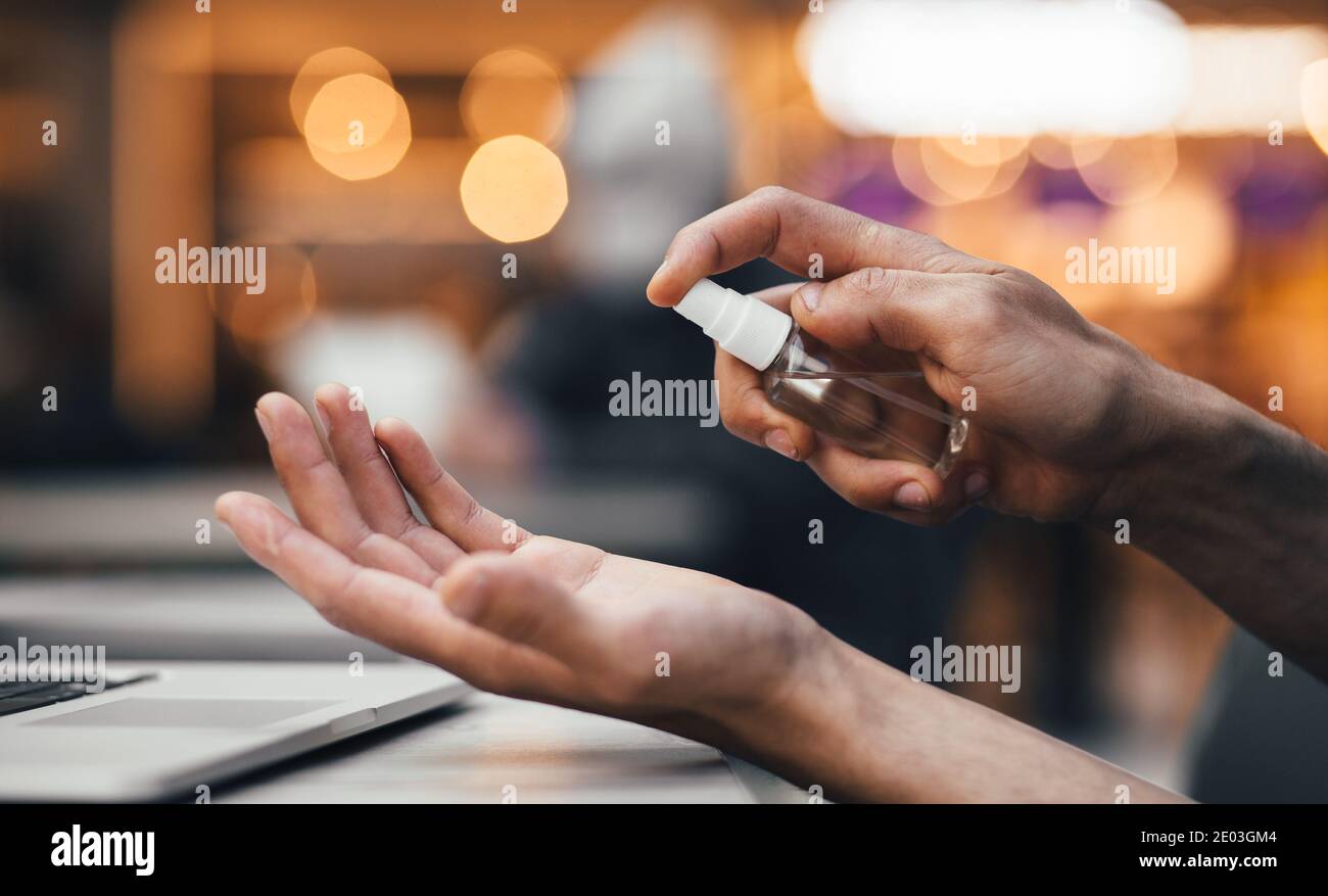 close up. man uses an antiseptic hand spray Stock Photo - Alamy