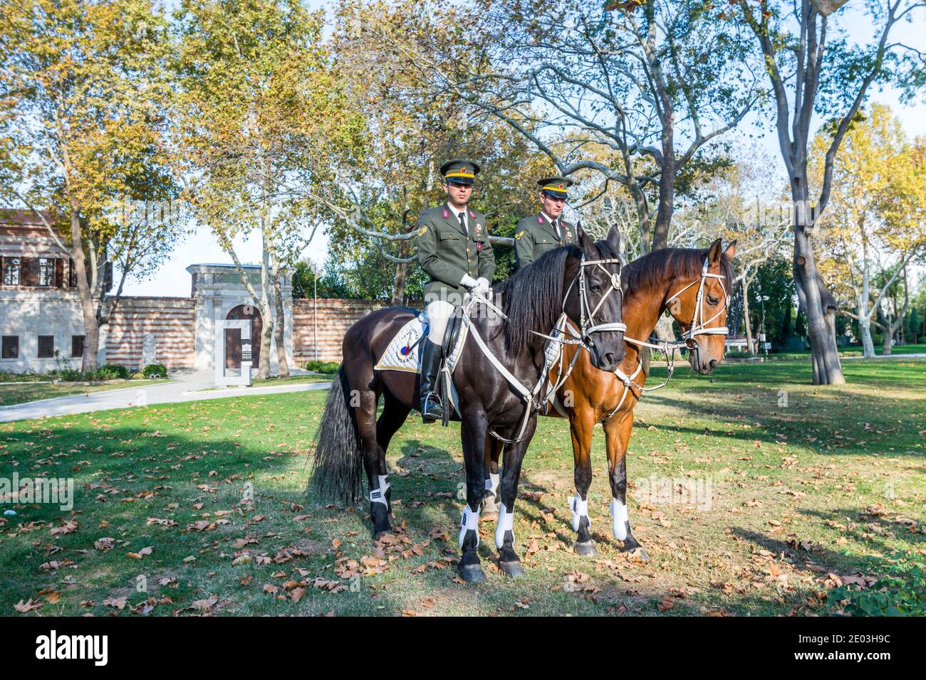 Two guards riding horses and wearing green uniform in the park Topkapi ...