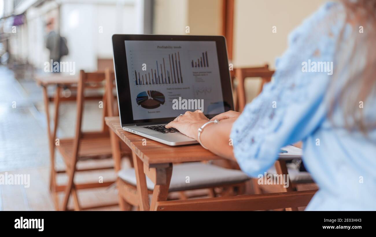 business woman analyzing financial data sitting at a table in a cafe ...