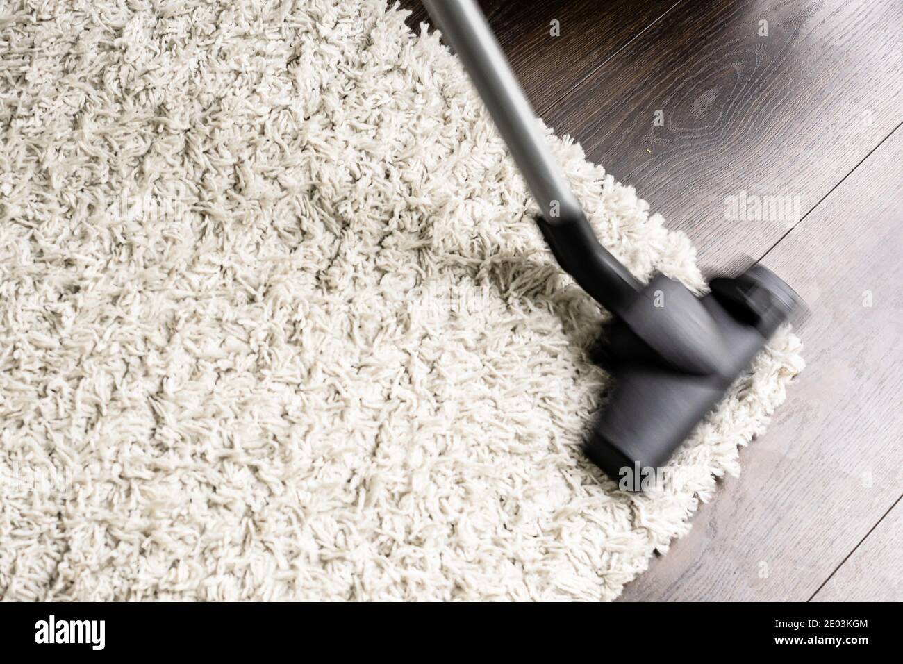 Nozzle of a vacuum cleaner moving rapidly over a white rug Stock Photo ...