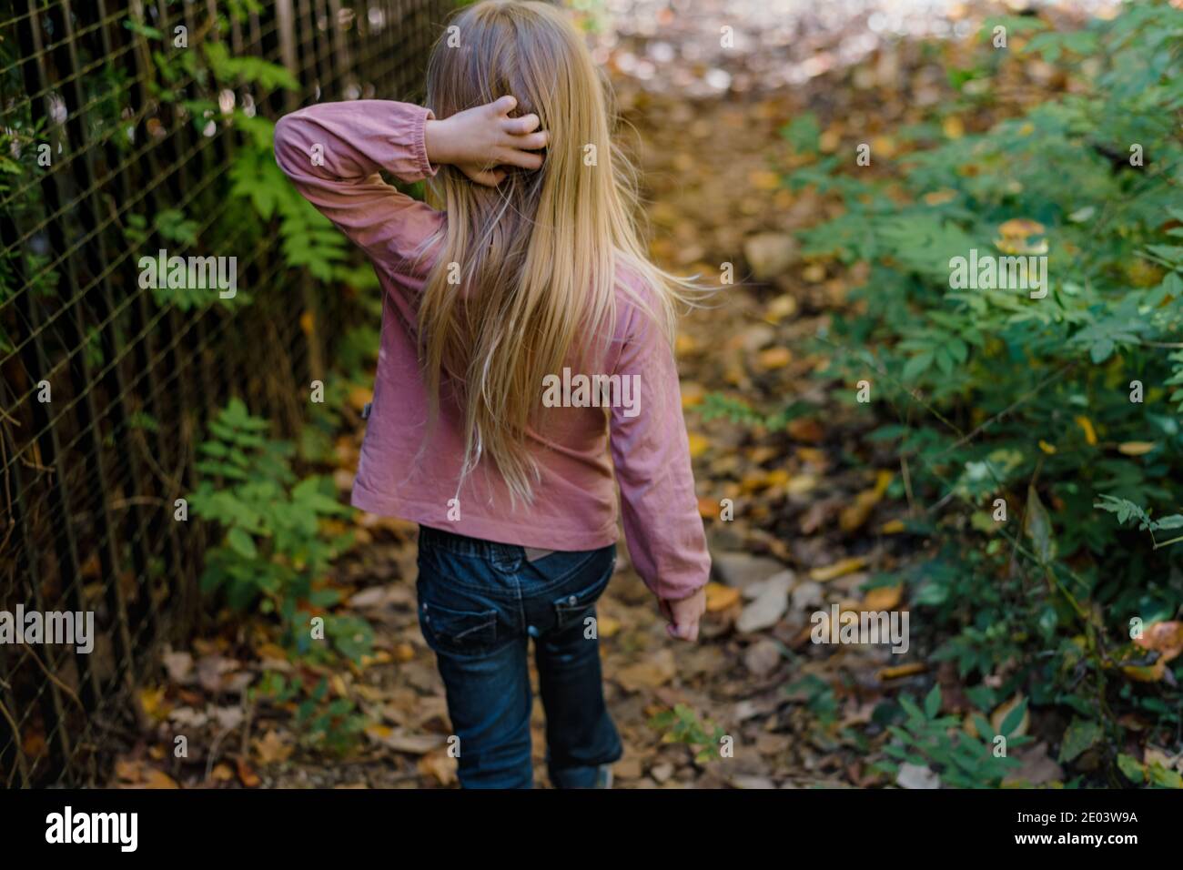 Little girl scratching head while hiking in forest Stock Photo - Alamy