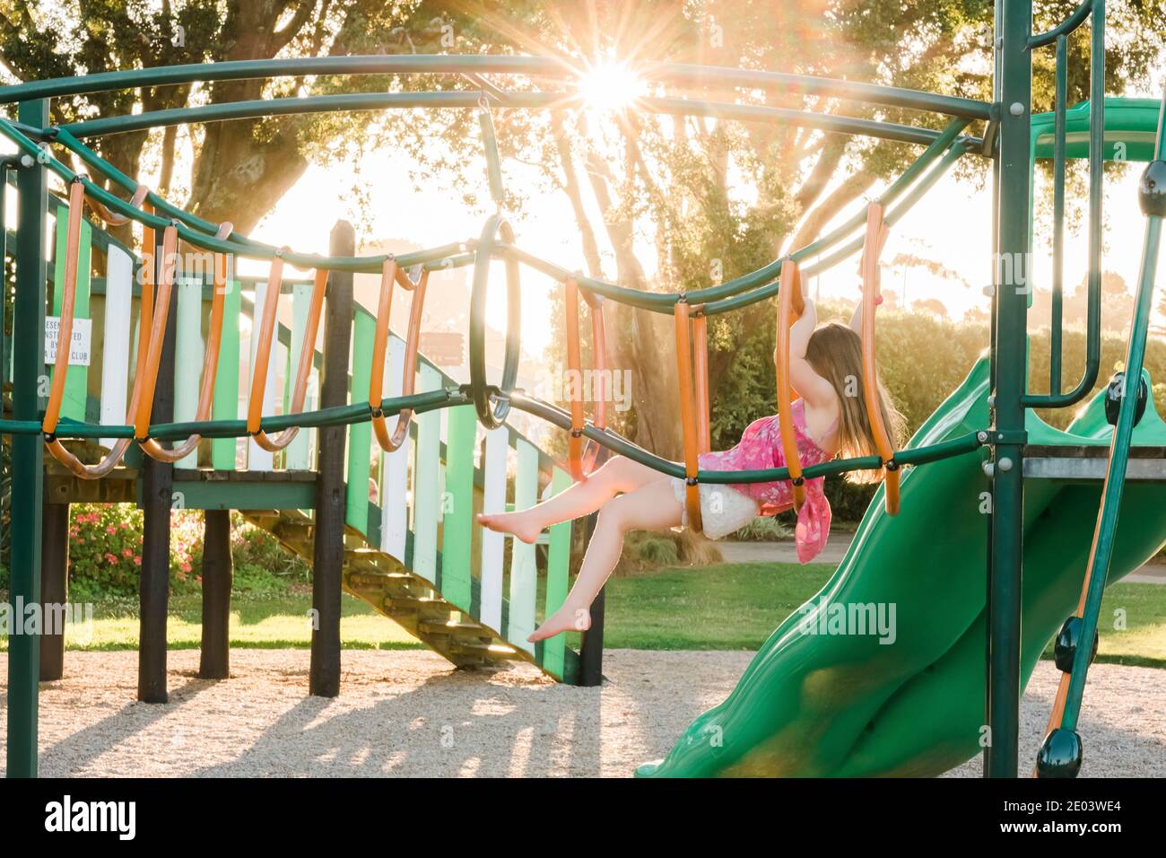 Girl playing on equipment at the playground Stock Photo - Alamy