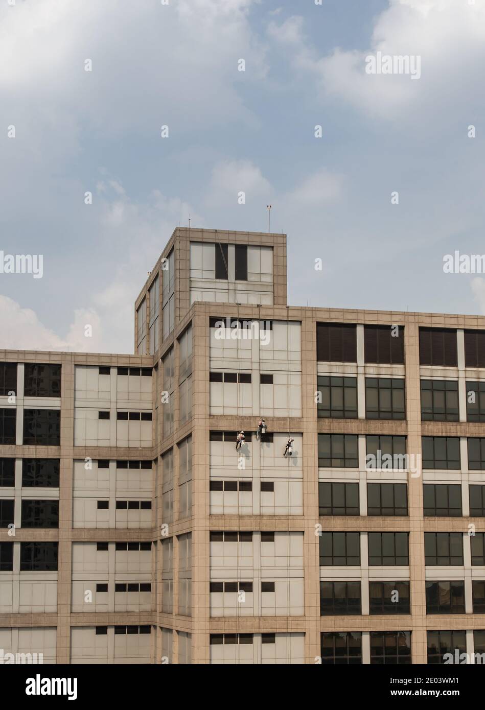 Group of workers cleaning windows service on high rise office building ...