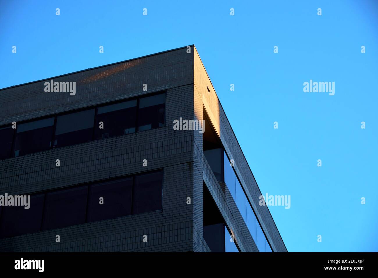 A graphic look at the sharp corner of a white brick office building ...