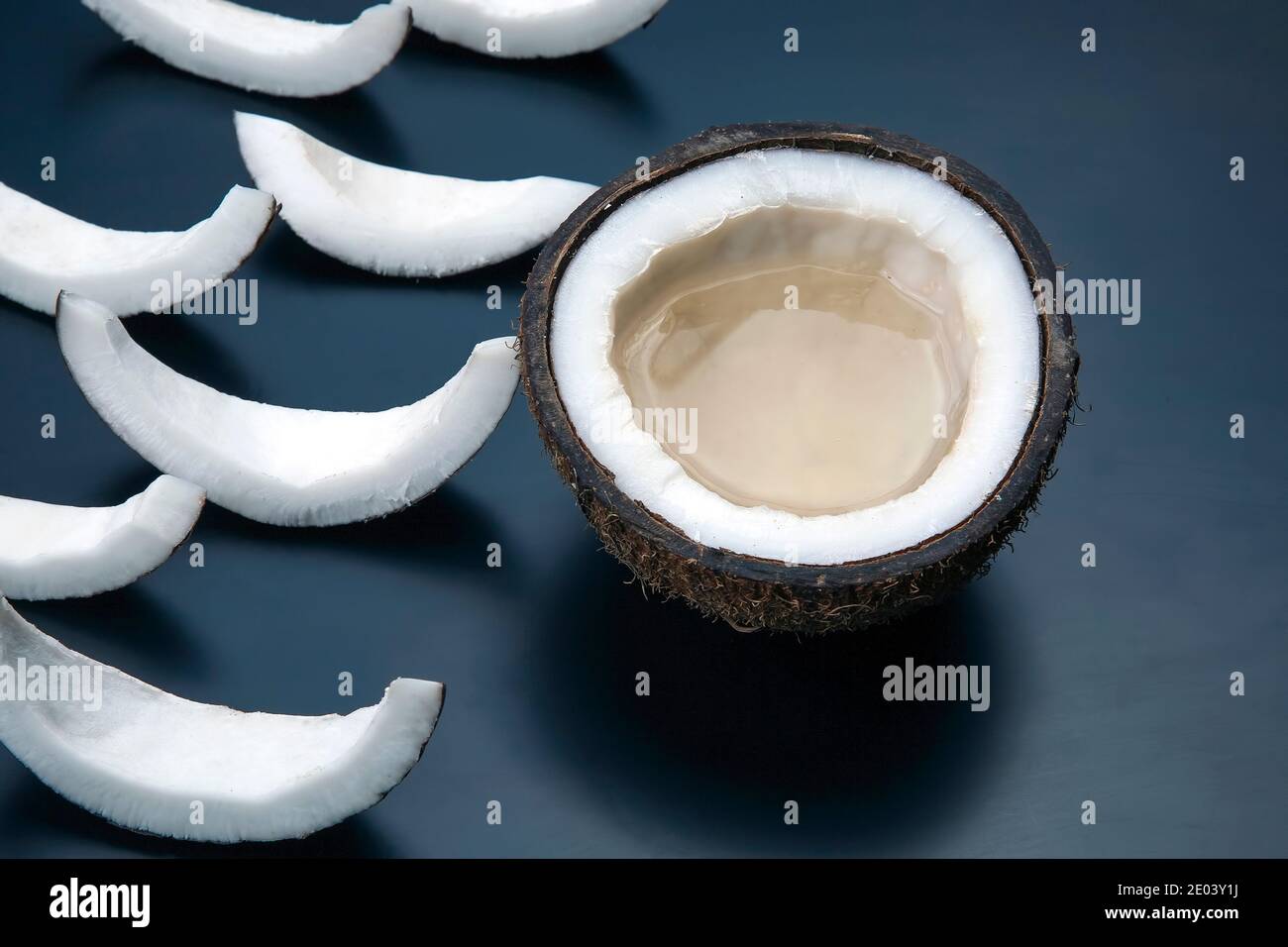 pieces of chopped coconut on a dark background. vitamin fruits. healthy ...