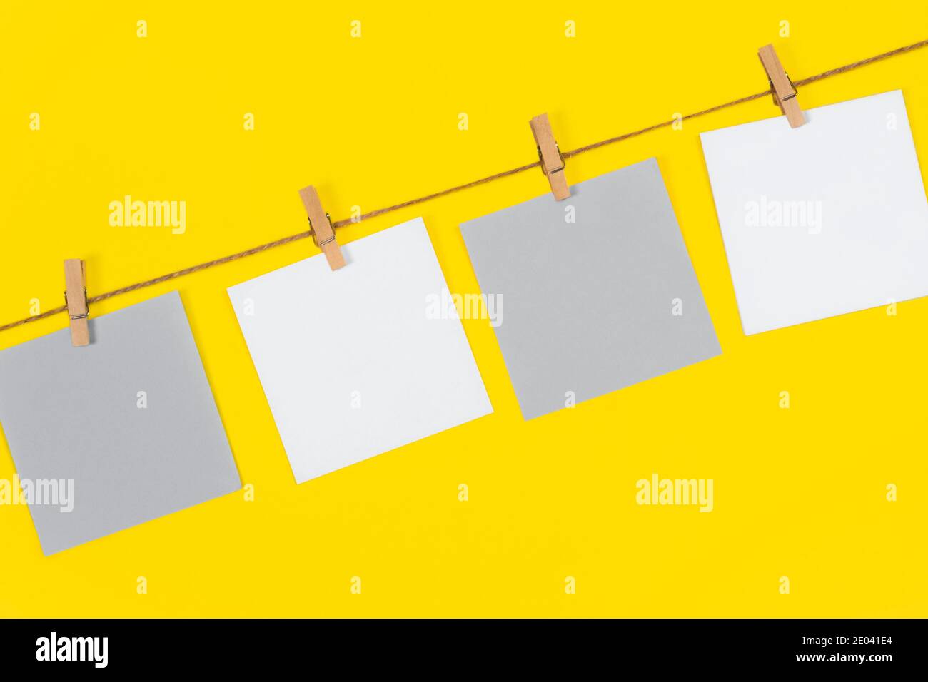 Note papers and decorative pin or clip isolated on yellow background ...