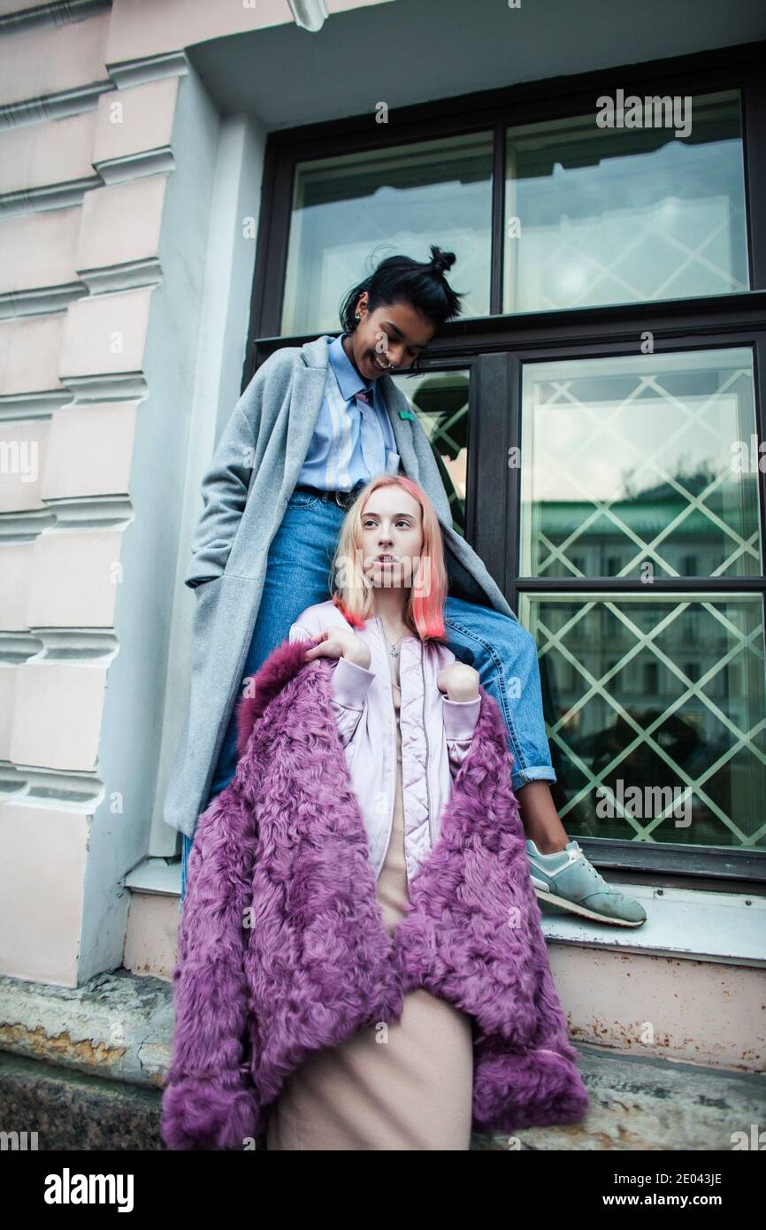 Two teenage girls infront of university building smiling, having fun ...