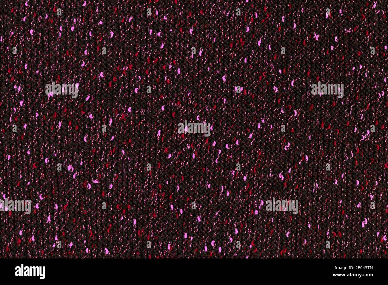 black melange manually knitted fabric with red and pink blotches ...