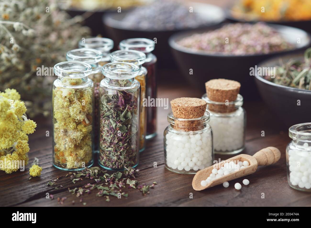 Three bottles of homeopathic globules, bottles of dried medicinal herbs ...