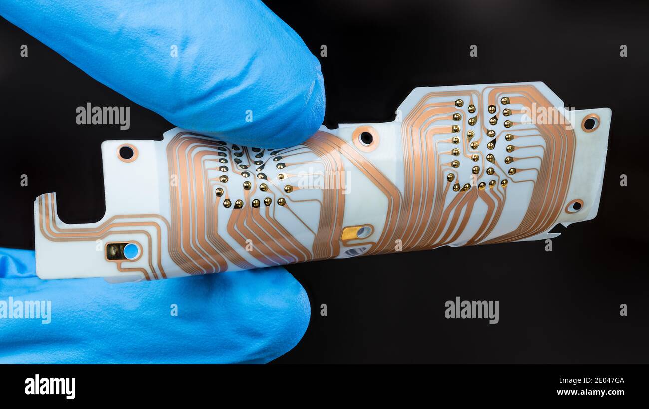 Flex printed circuit board in man fingers isolated on a black ...