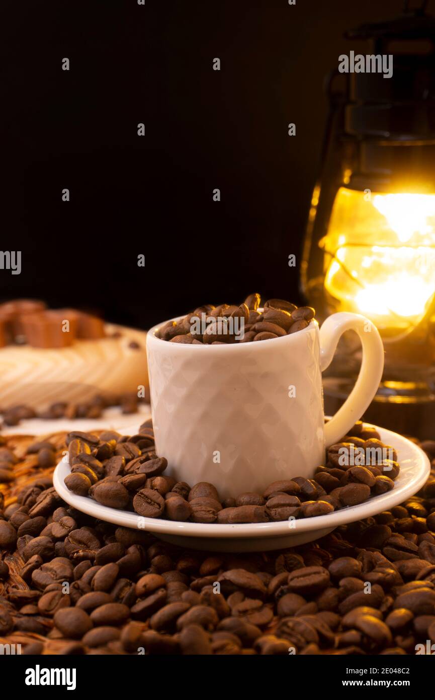 coffee beans inside and around of a classic espresso mug in a black ...