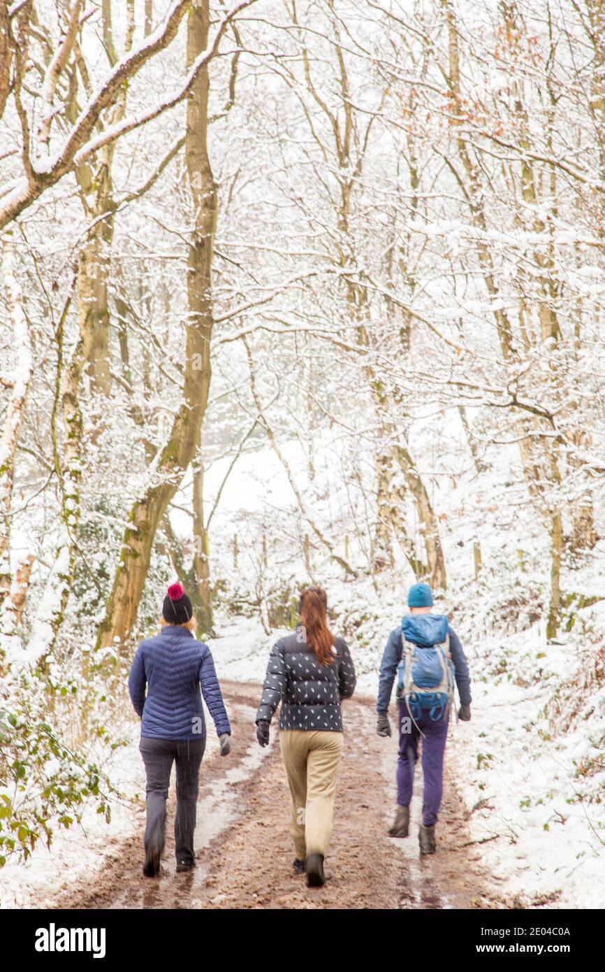 People families and children walking along a path in snow covered ...