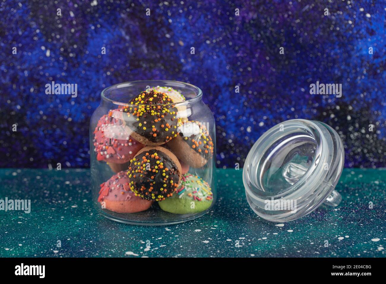 A glass jar full of small colorful doughnuts Stock Photo - Alamy
