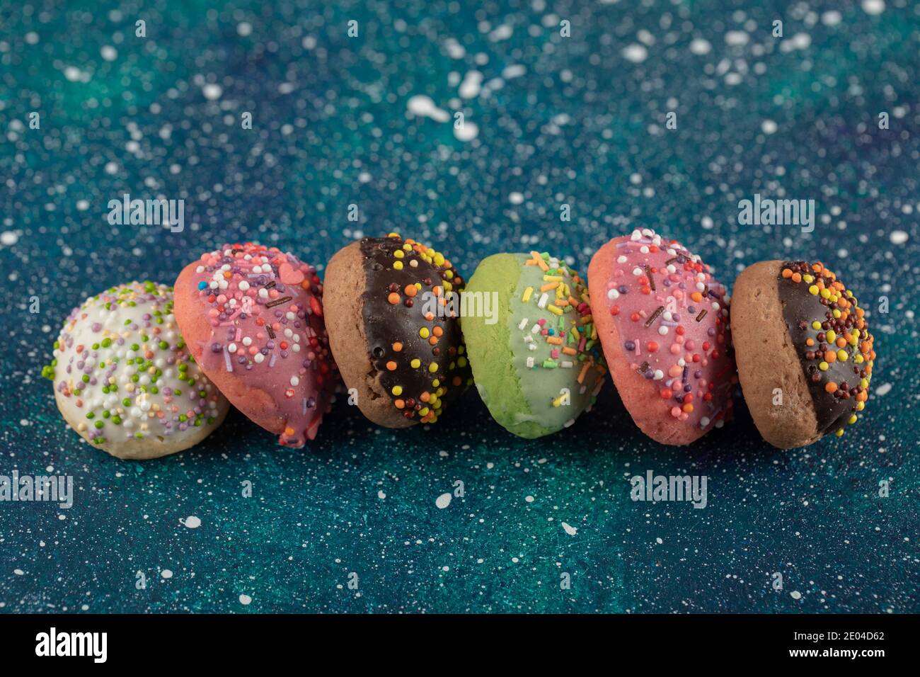 Colorful small doughnuts with sprinkles on a blue background Stock ...
