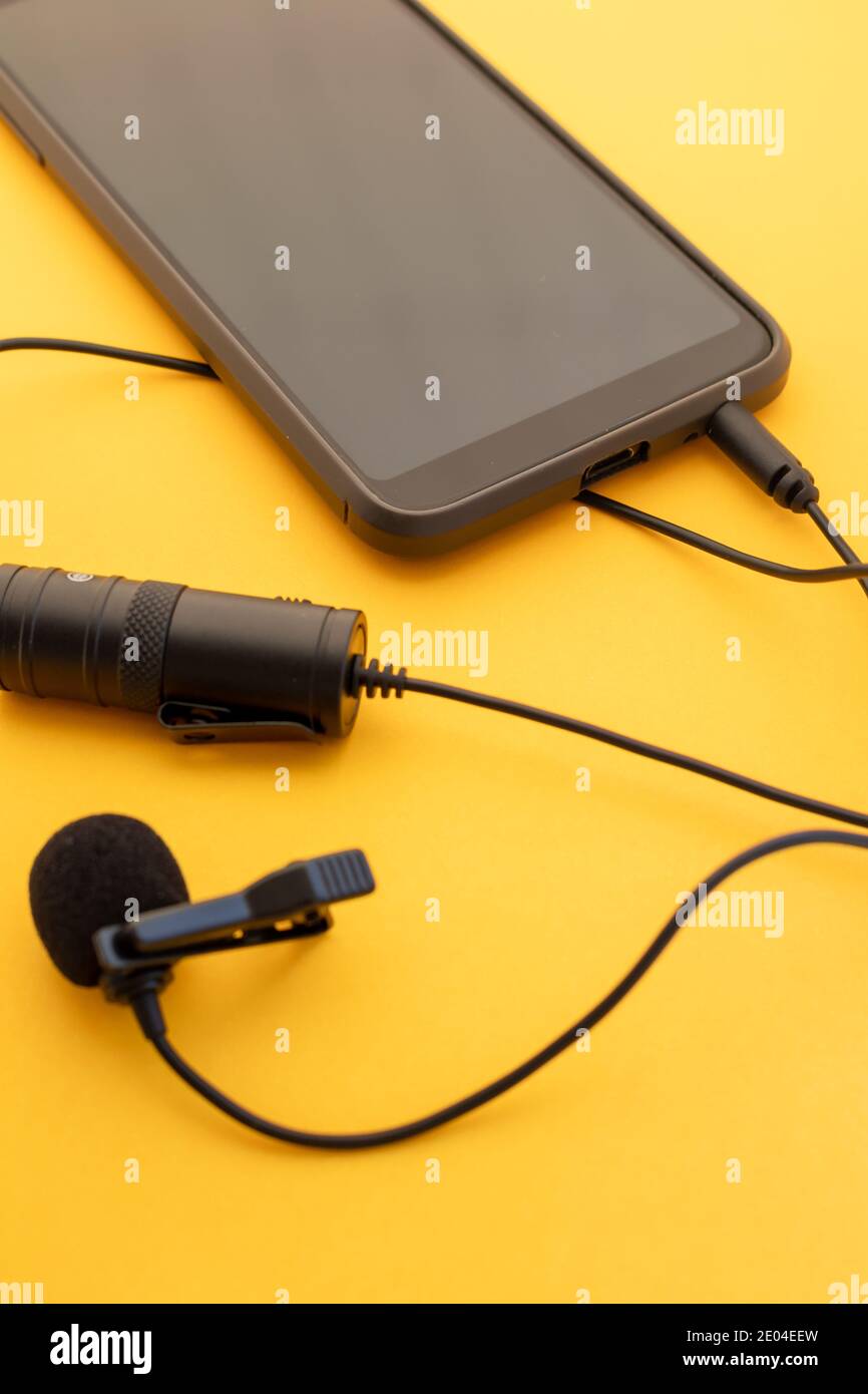 Lavalier or lapel microphone on a colored surface plugged into a cell ...