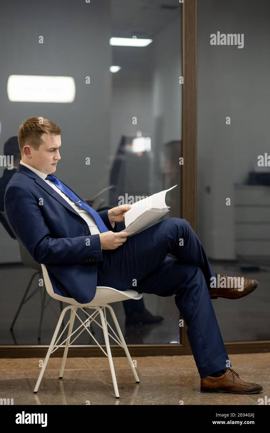 Young businessman working with documents looking through papers in ...