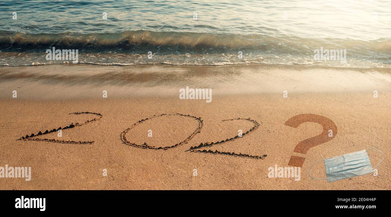 Text on sandy beach 202 question mark and face mask, concept of when ...