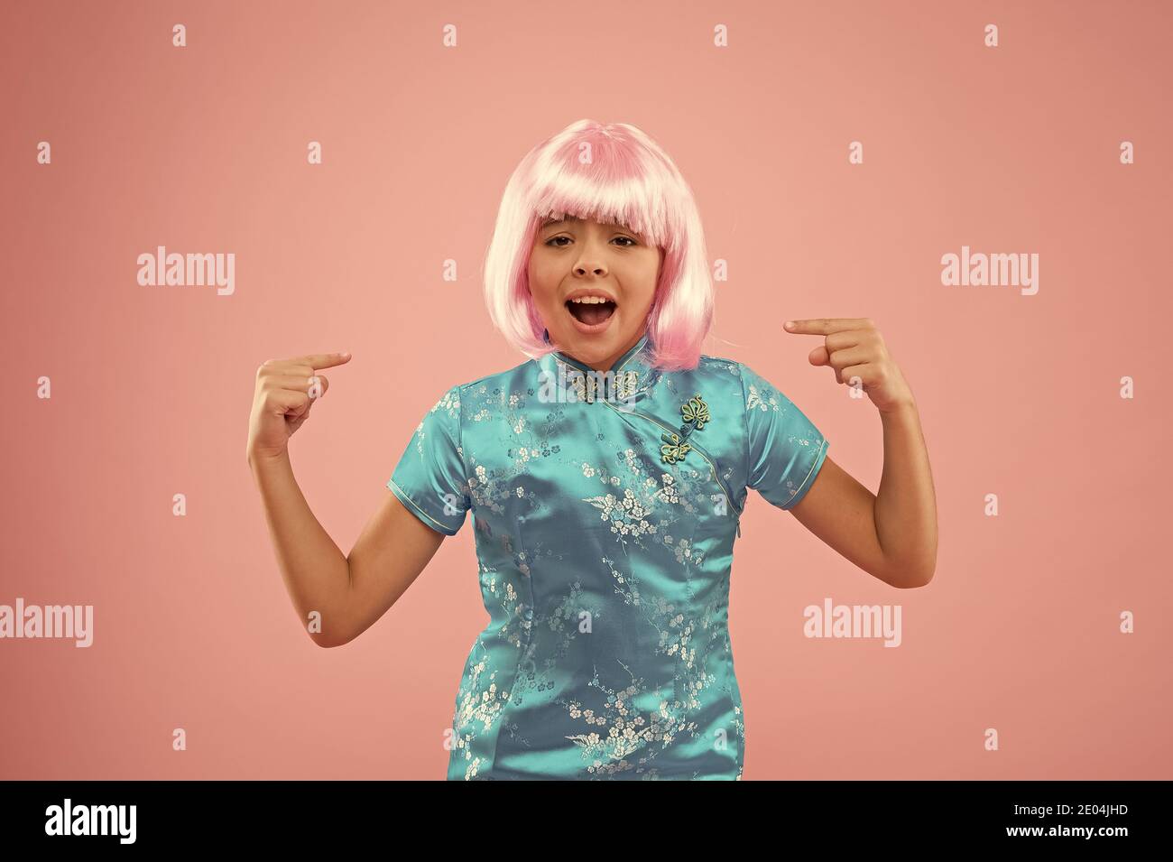 Look at this. Unhappy girl pointing fingers at wig. Small child ...