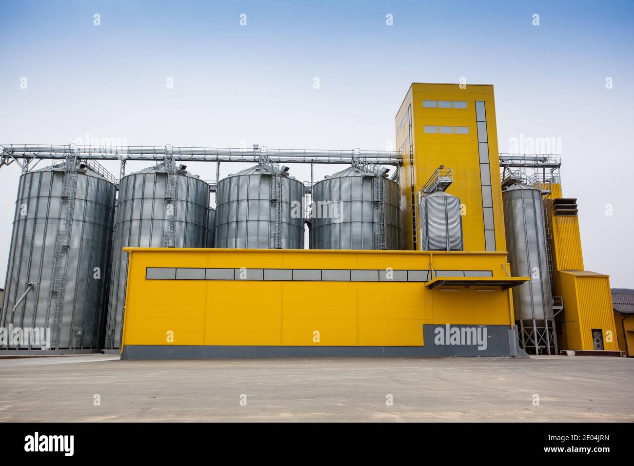 Cereal silos with a yellow building Stock Photo - Alamy