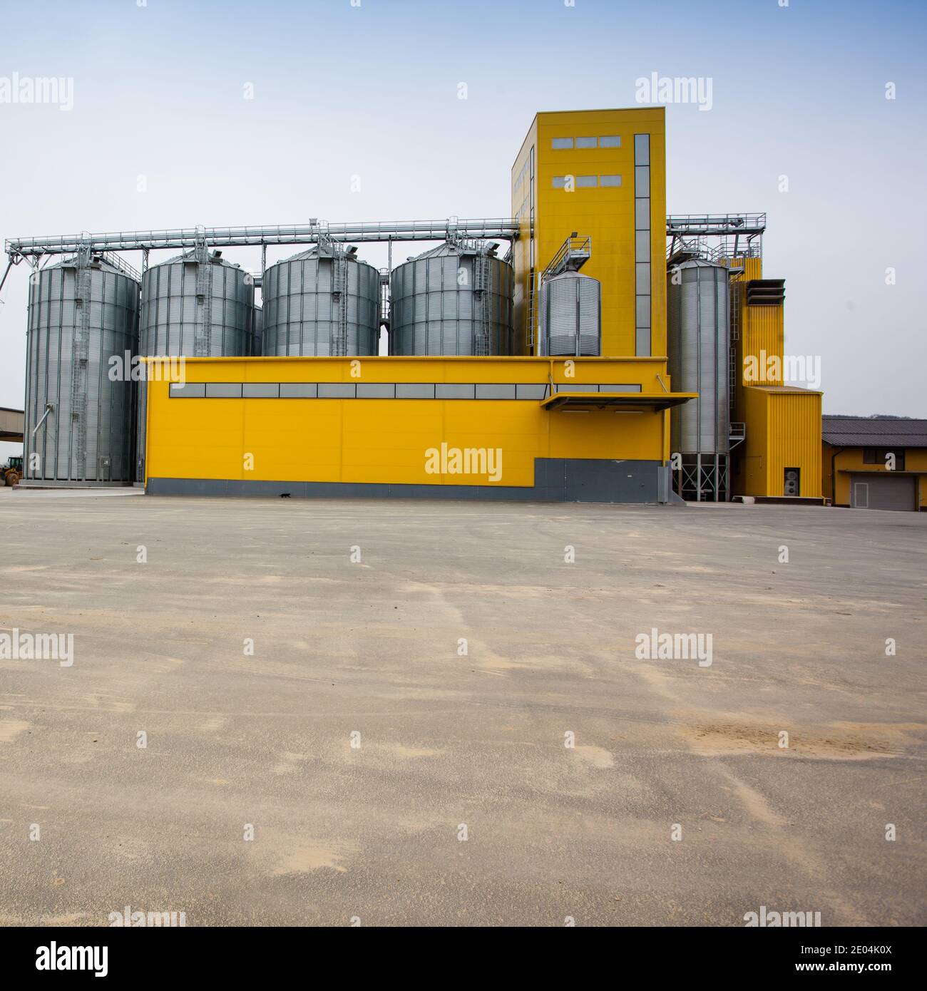 Cereal silos with a yellow building Stock Photo - Alamy