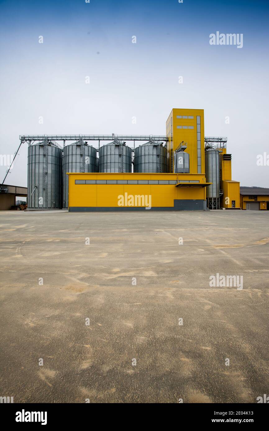 Cereal silos with a yellow building Stock Photo - Alamy