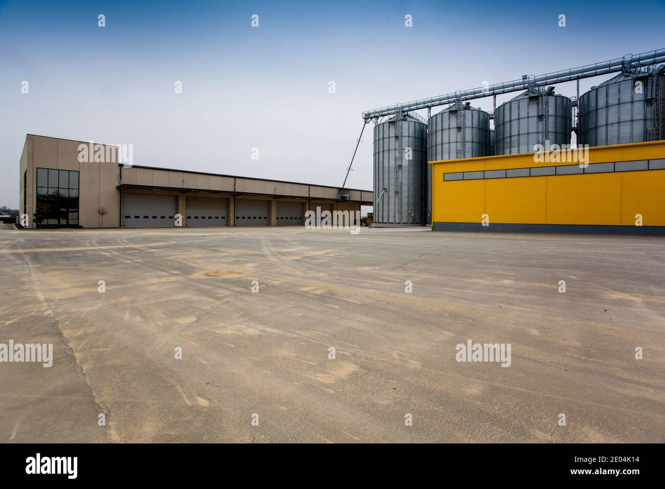 Cereal silos with a yellow building Stock Photo - Alamy