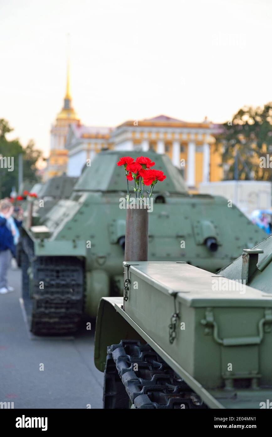 Red flowers in a gun cartridge on a medium Soviet tank T-34 on the ...