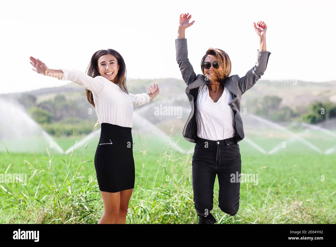 Two business women in a field, jumping and celebrating success Stock ...