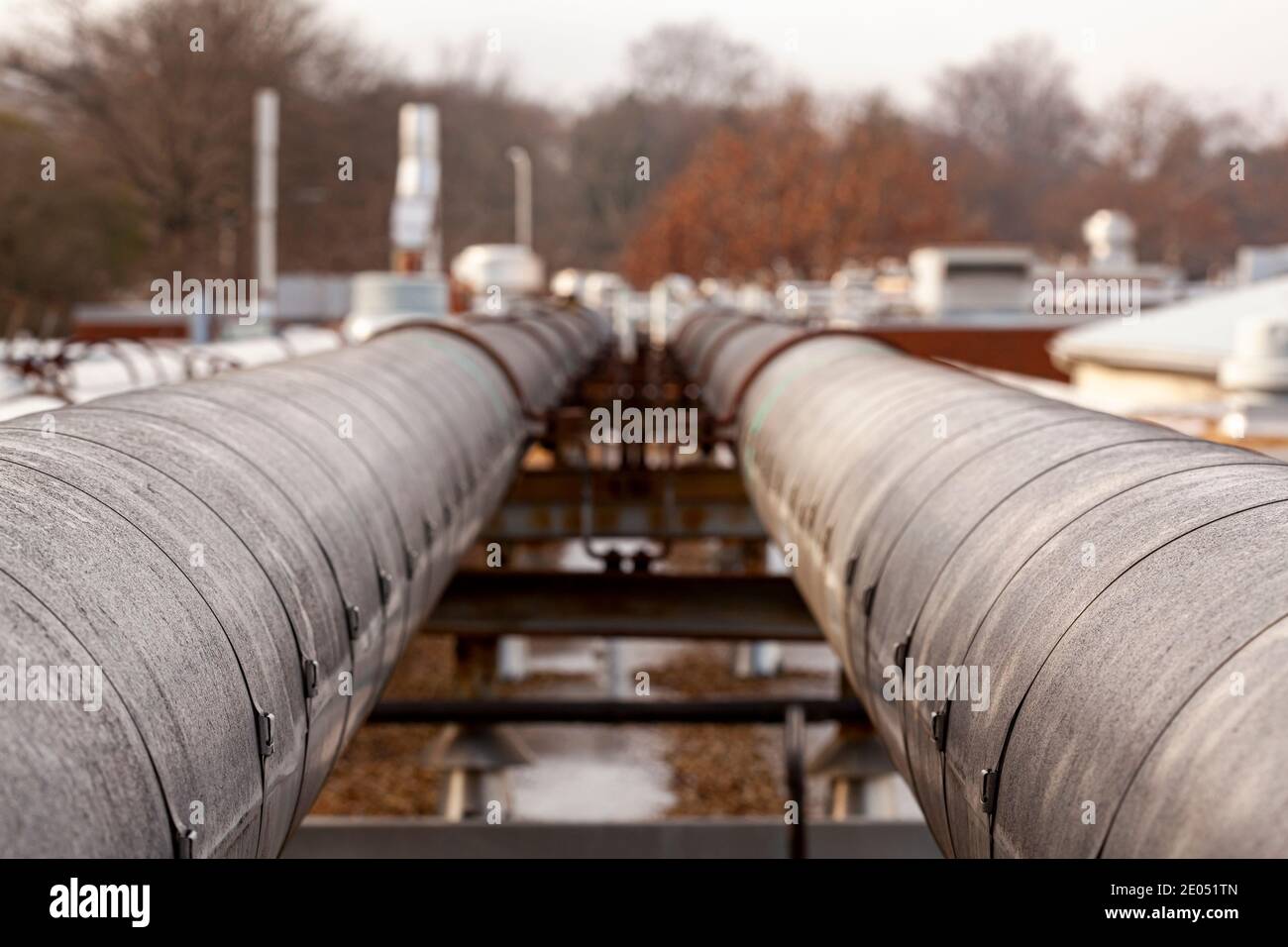 Close up view of a pipeline running over snowy terrain near an energy ...