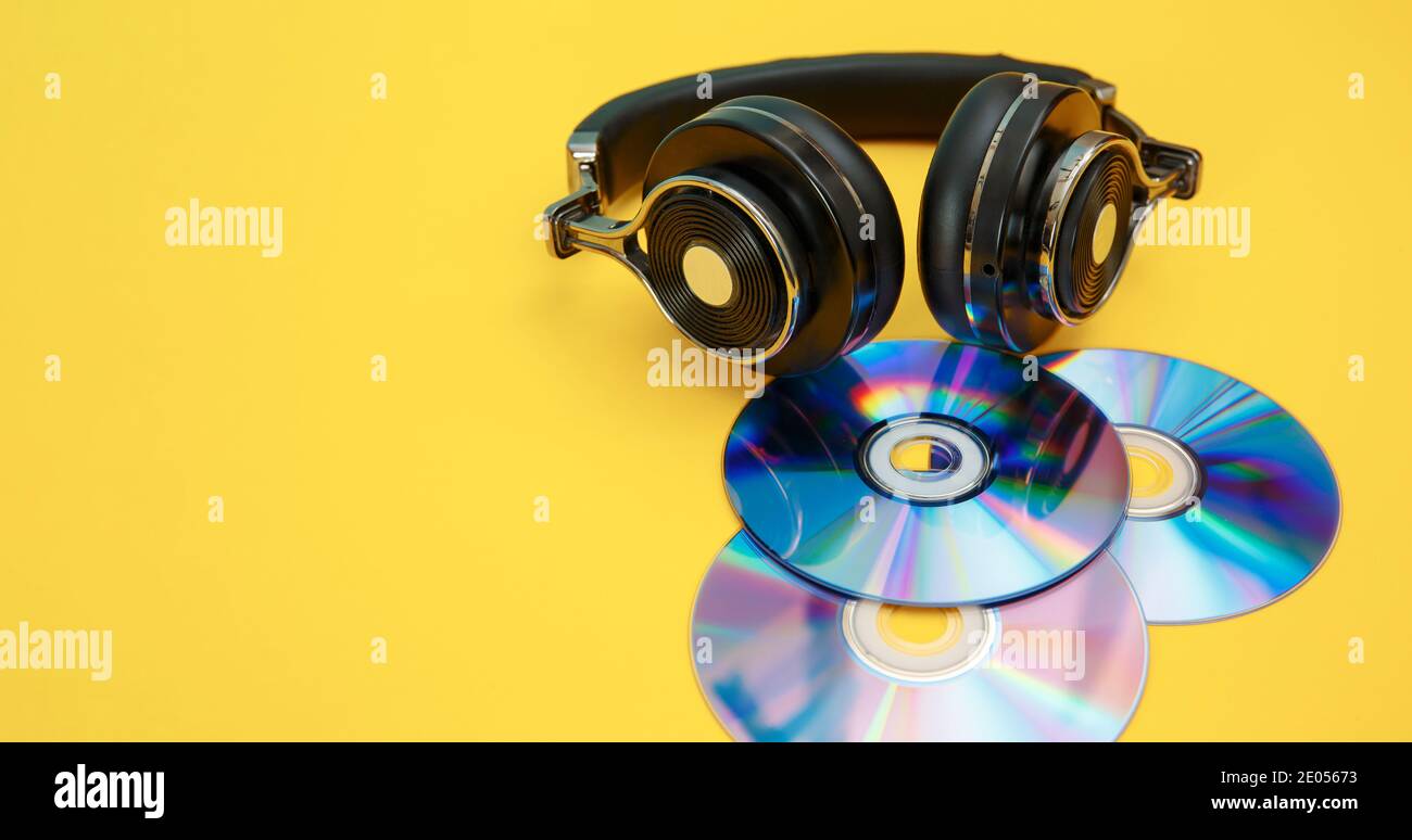 Headphones and music discs on a yellow background. Musical concept ...