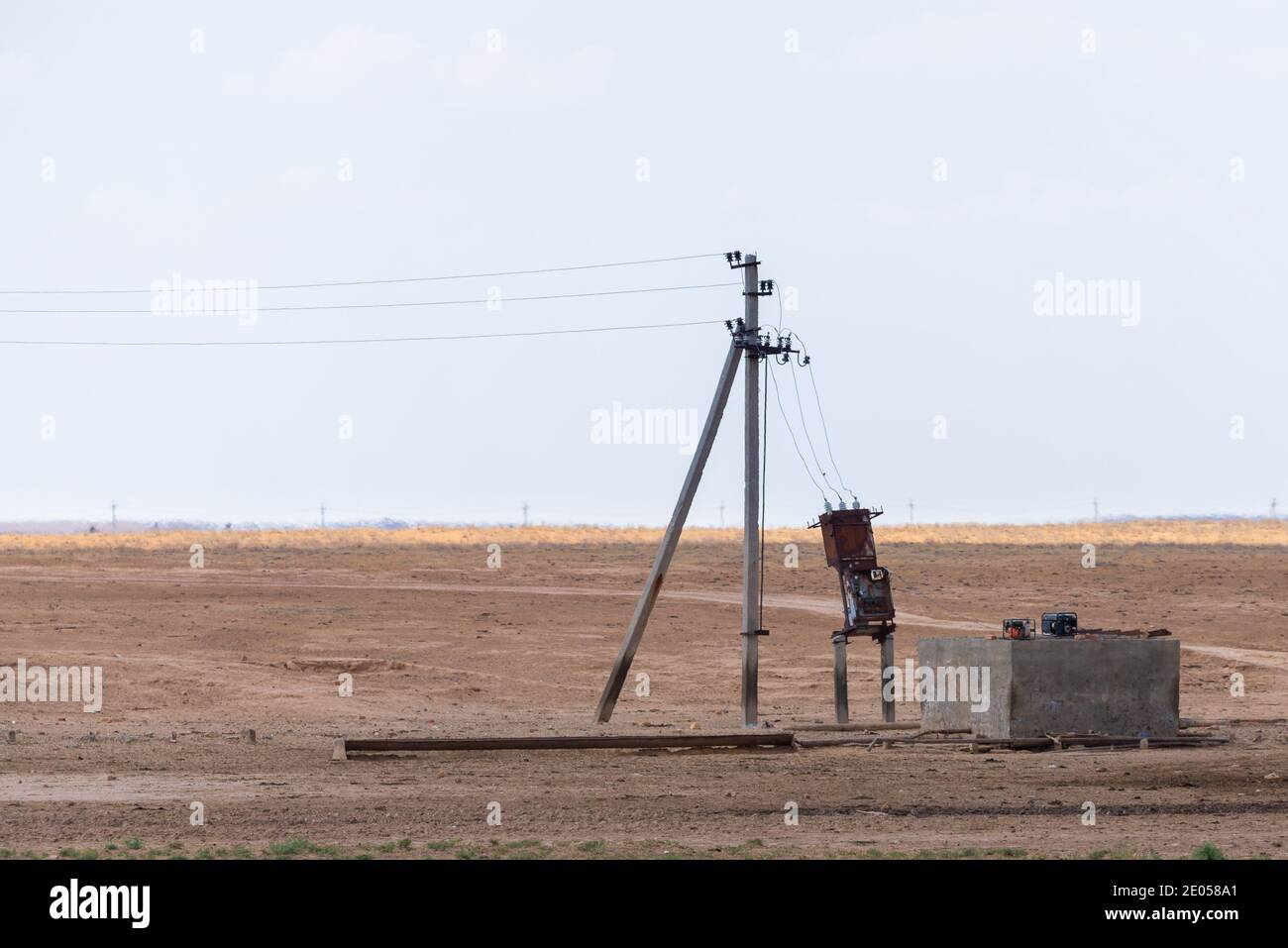 Transformer station near a pillar in steppe. Rural power lines ...