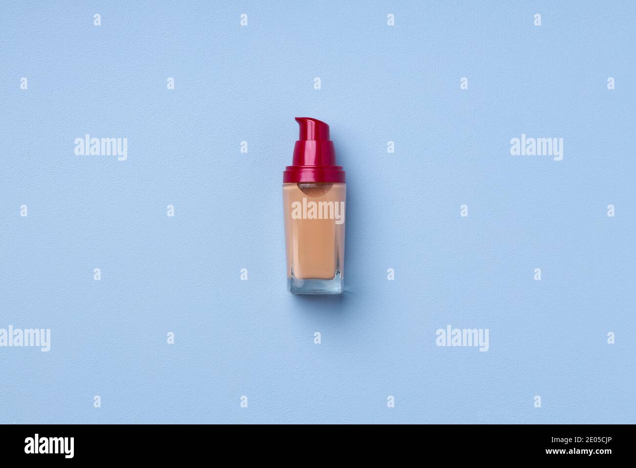 Liquid foundation tube on blue background close up Stock Photo - Alamy