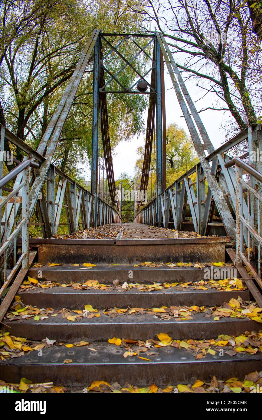Entrance to the old pedestrian suspension bridge strewn with fallen ...