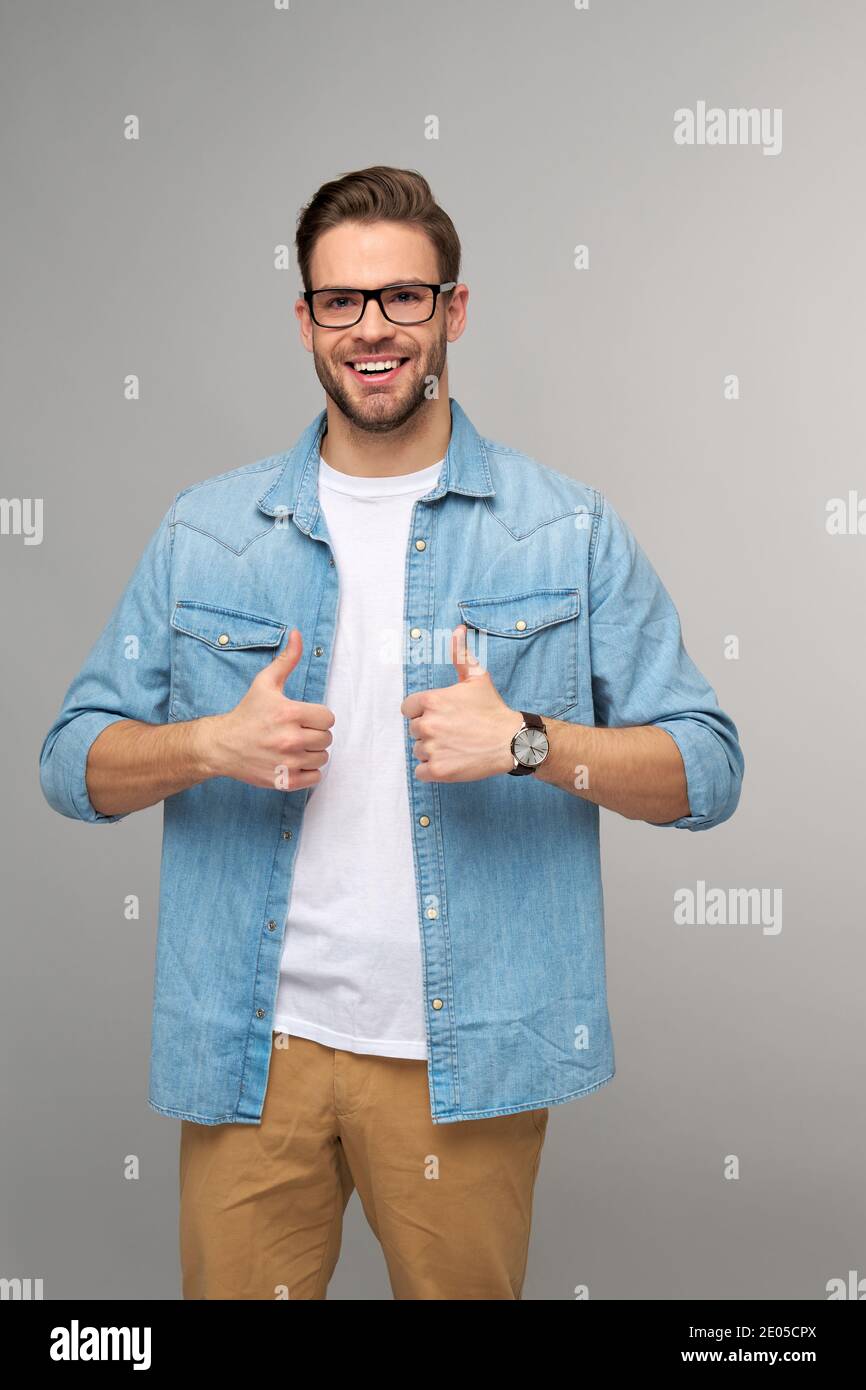 Portrait of young handsome caucasian man in jeans shirt showing big ...